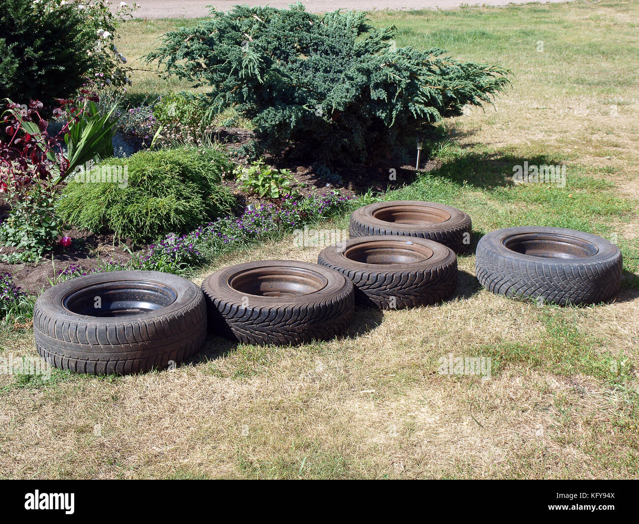 Car wheels on ground near flower bed Stock Photo - Alamy