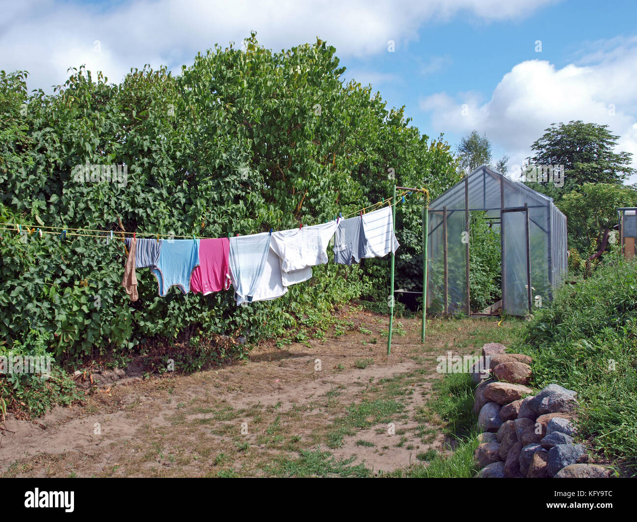Drying clothes on the rope in country yard Stock Photo - Alamy
