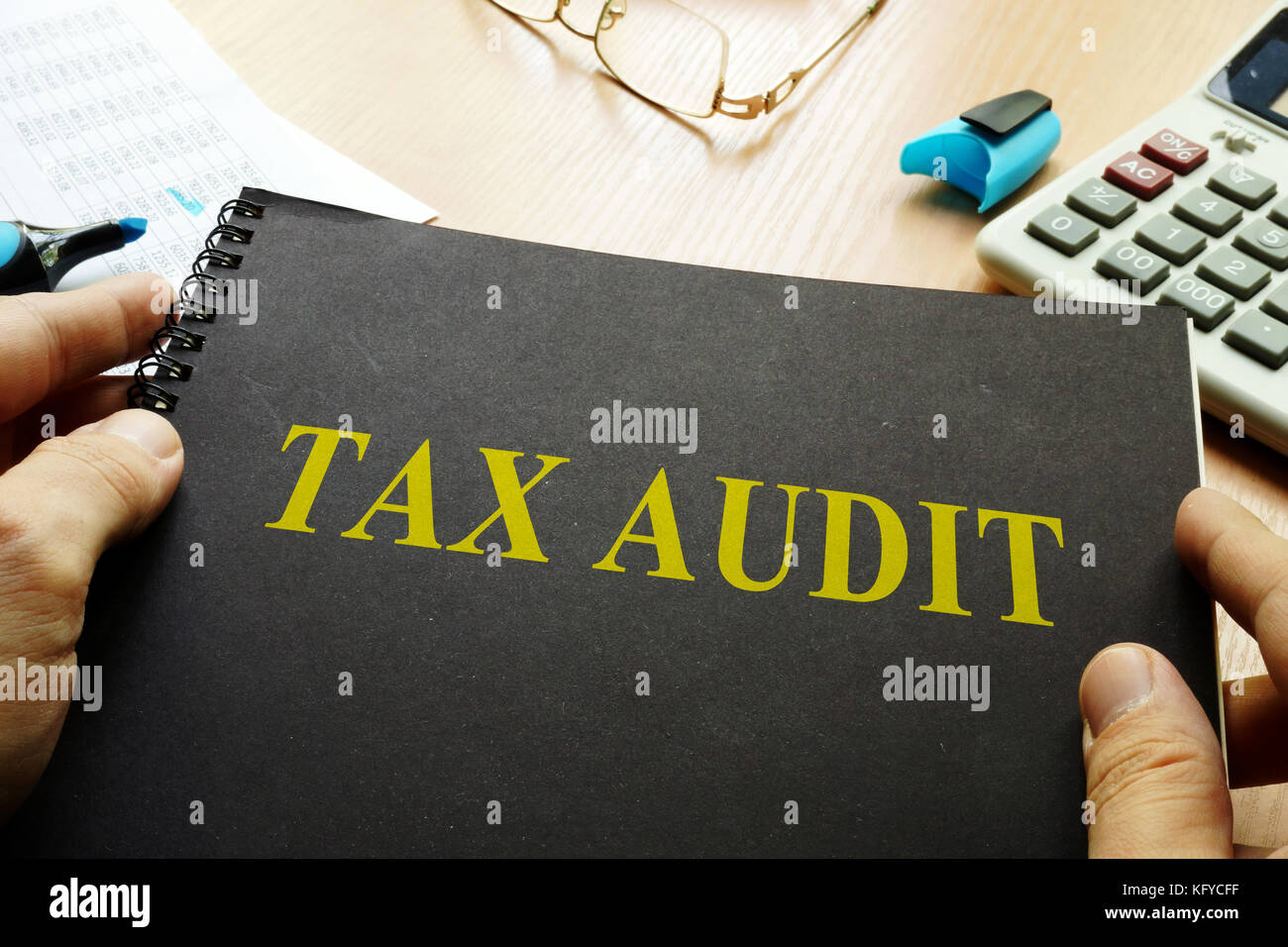 Book about tax audit and calculator on a desk Stock Photo - Alamy