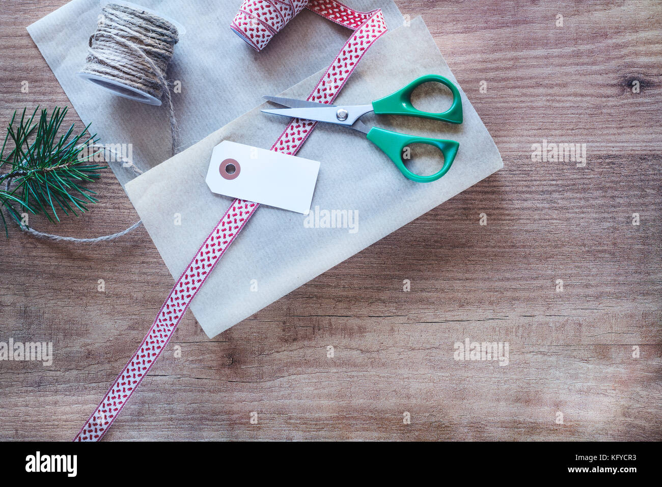Wrapping process of Christmas gifts with rustic paper and ribbon on ...
