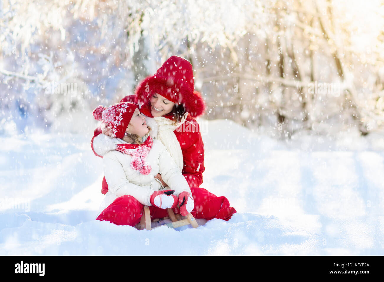 Mother and baby on sleigh ride. Child and mom sledding. Toddler kid ...