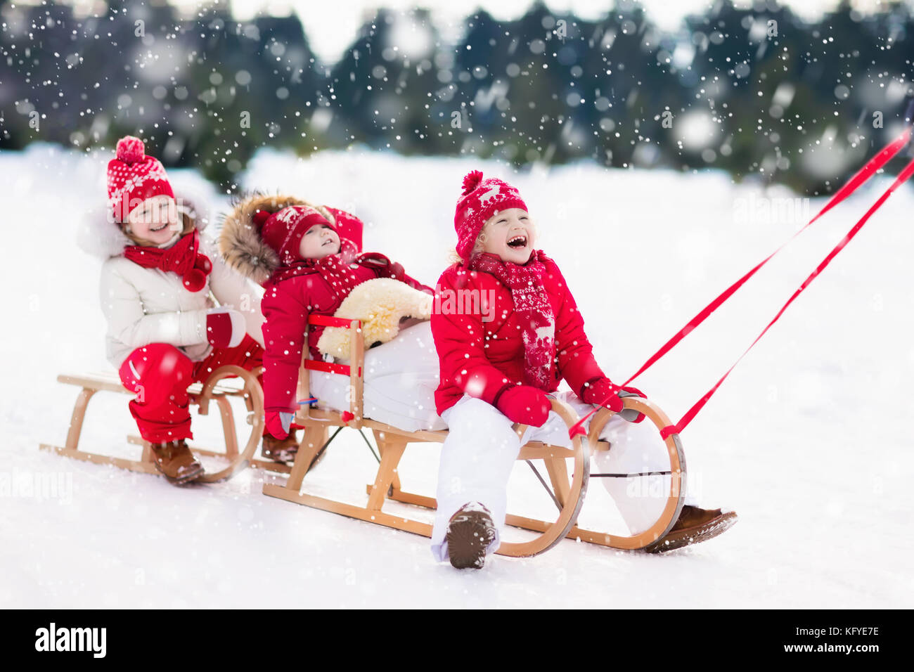 Little girl and boy enjoy a sleigh ride. Child sledding. Toddler kid ...