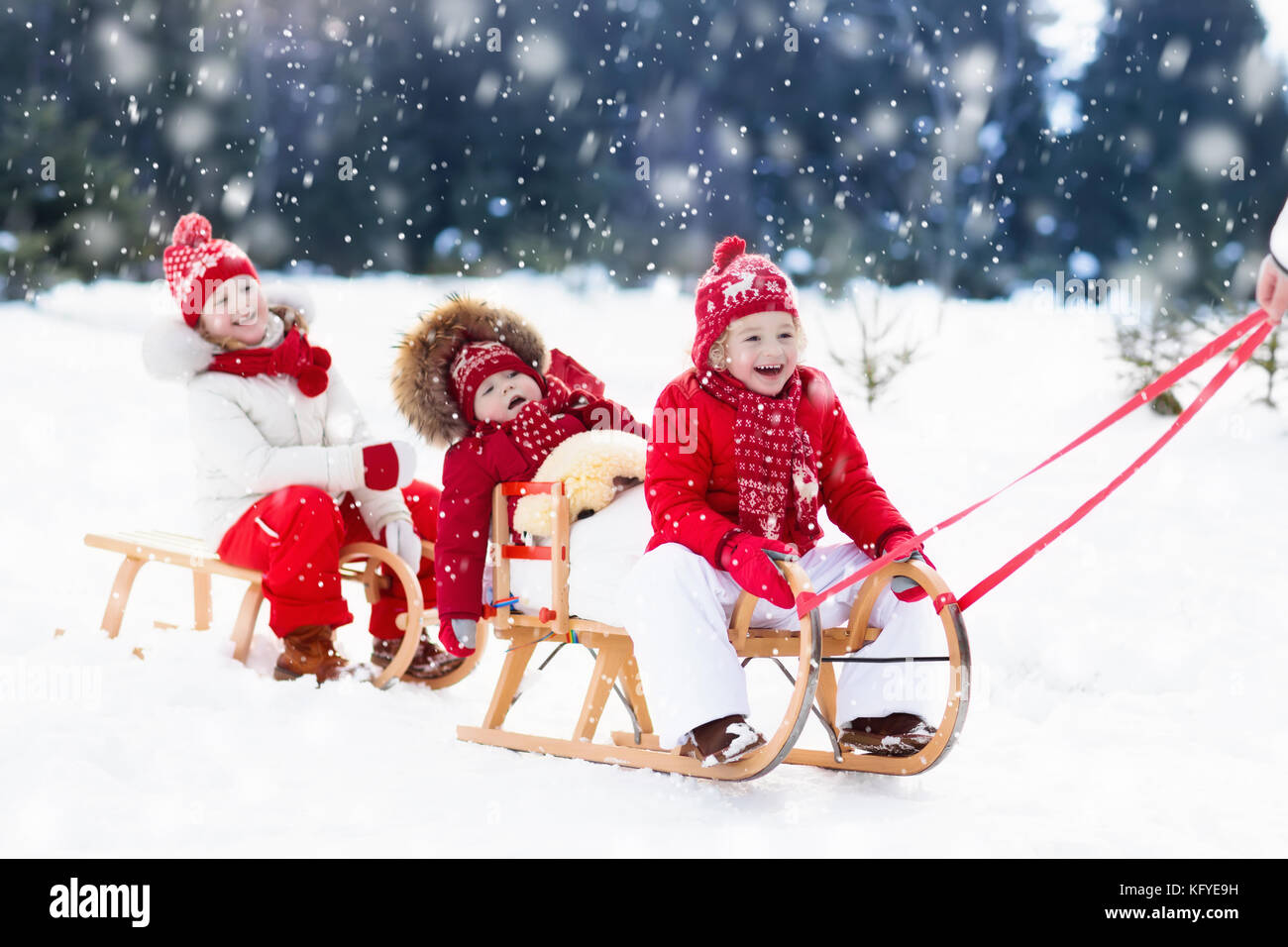 Little girl and boy enjoy a sleigh ride. Child sledding. Toddler kid ...