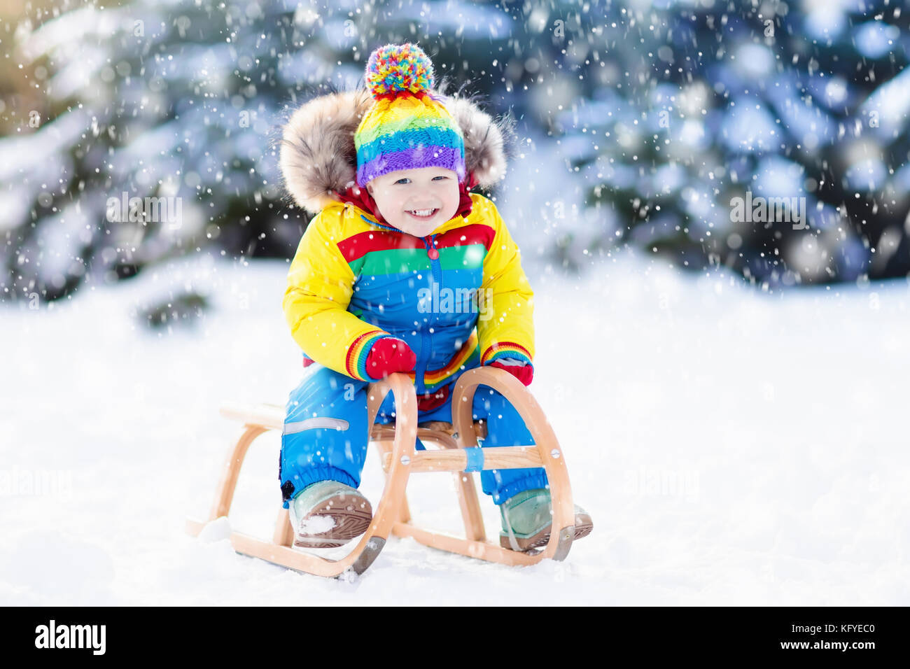 Little boy enjoying a sleigh ride. Child sledding. Toddler kid riding a ...
