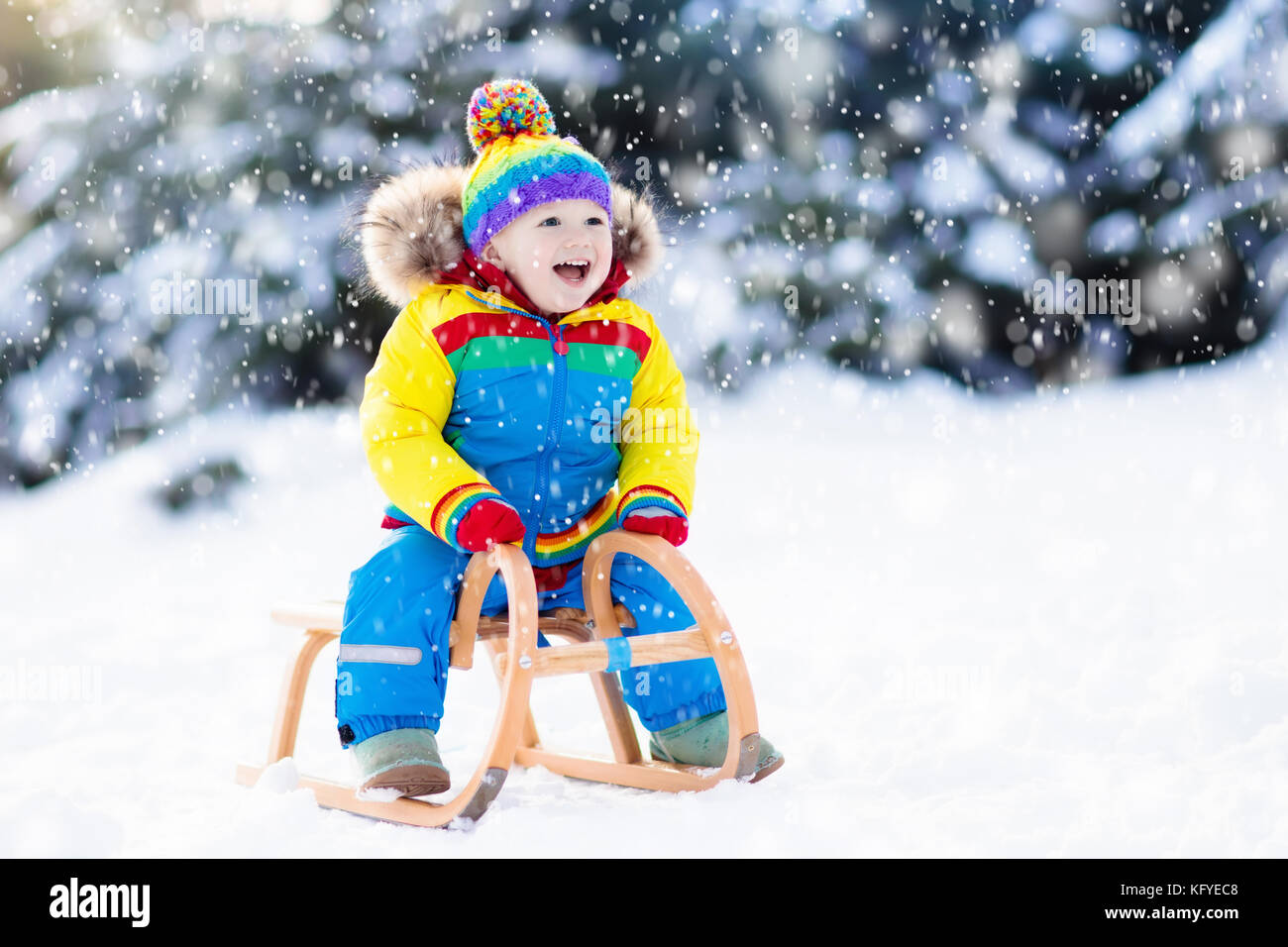 Little boy enjoying a sleigh ride. Child sledding. Toddler kid riding a ...