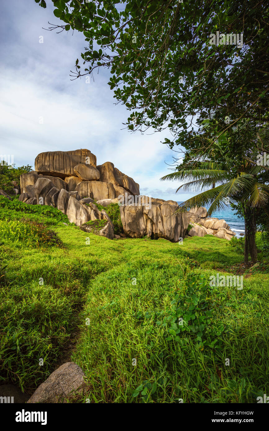 Hiking a footpath in the wilderness to mighty red granite rocks in lush ...