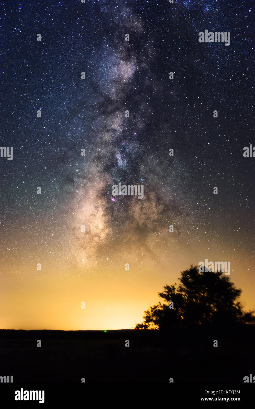 Beautiful night sky with vivid milky way. Yellow light polution at ...