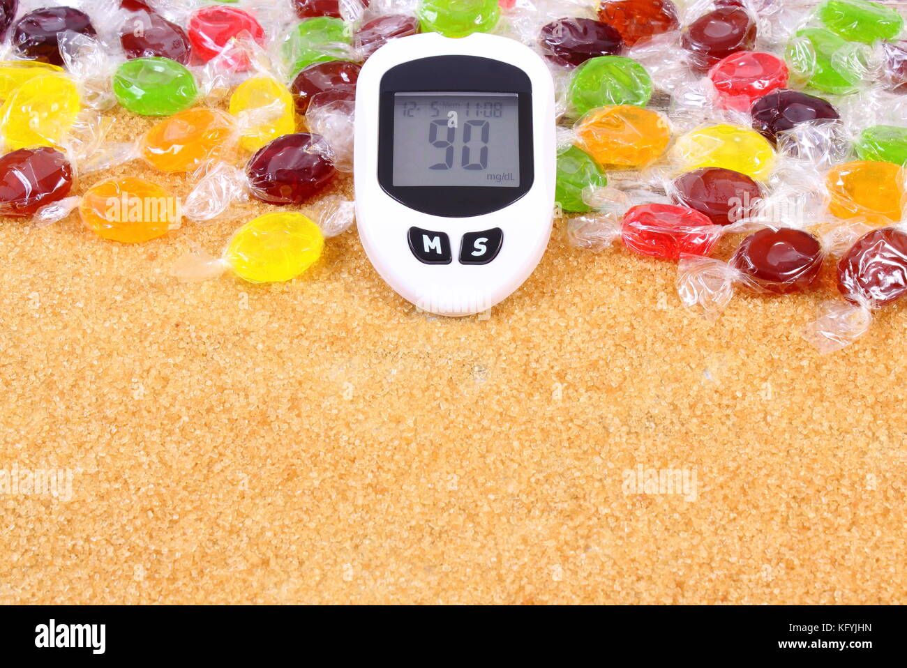 Glucose meter with result of measurement sugar level, colorful candies ...