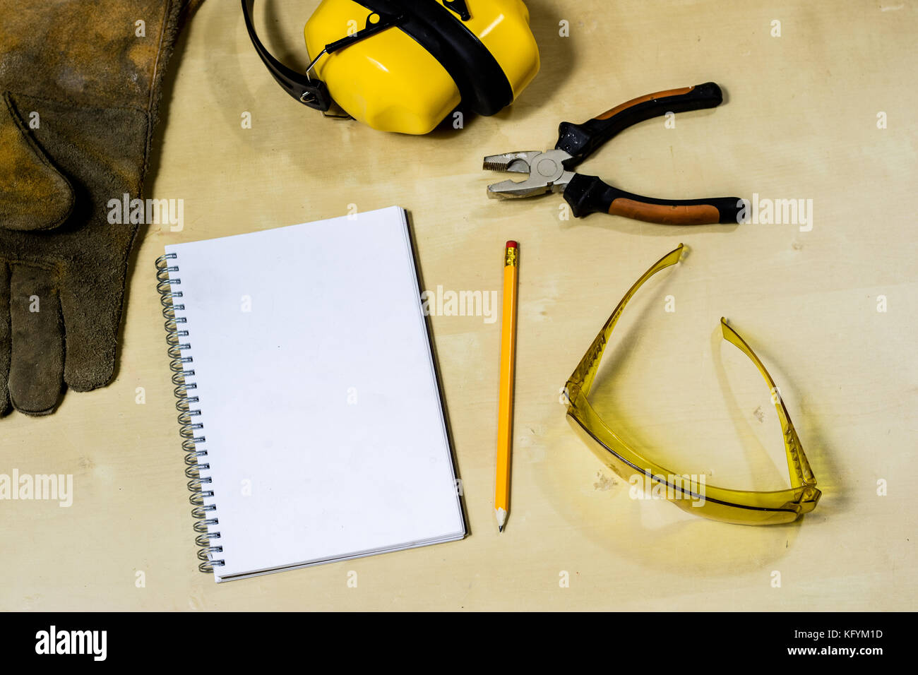 helmet, hearing protection, tools, workshop table. Safety equipment and ...