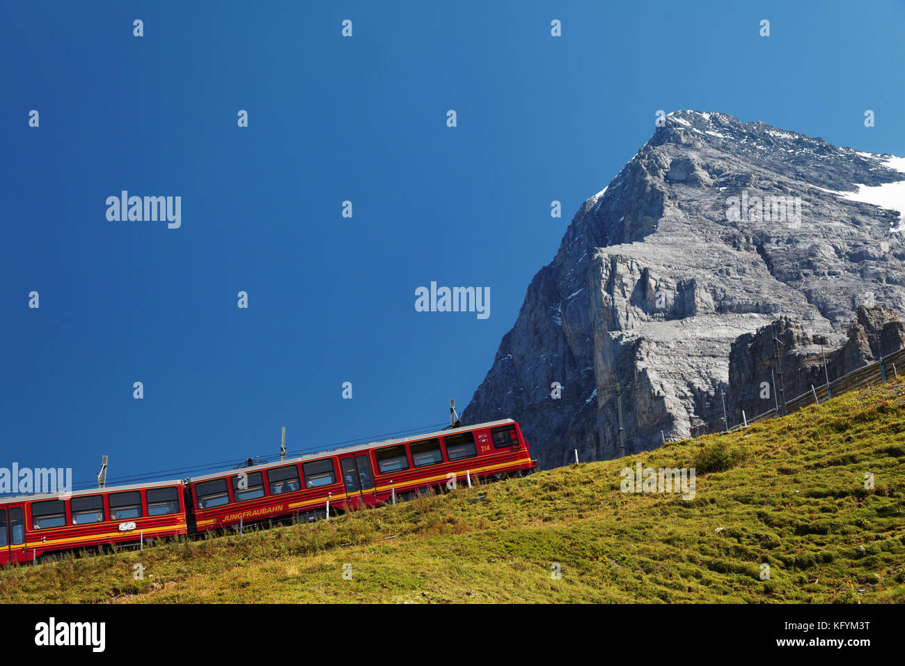 Red rail cars on the Jungfrau railway run below the north face of the ...