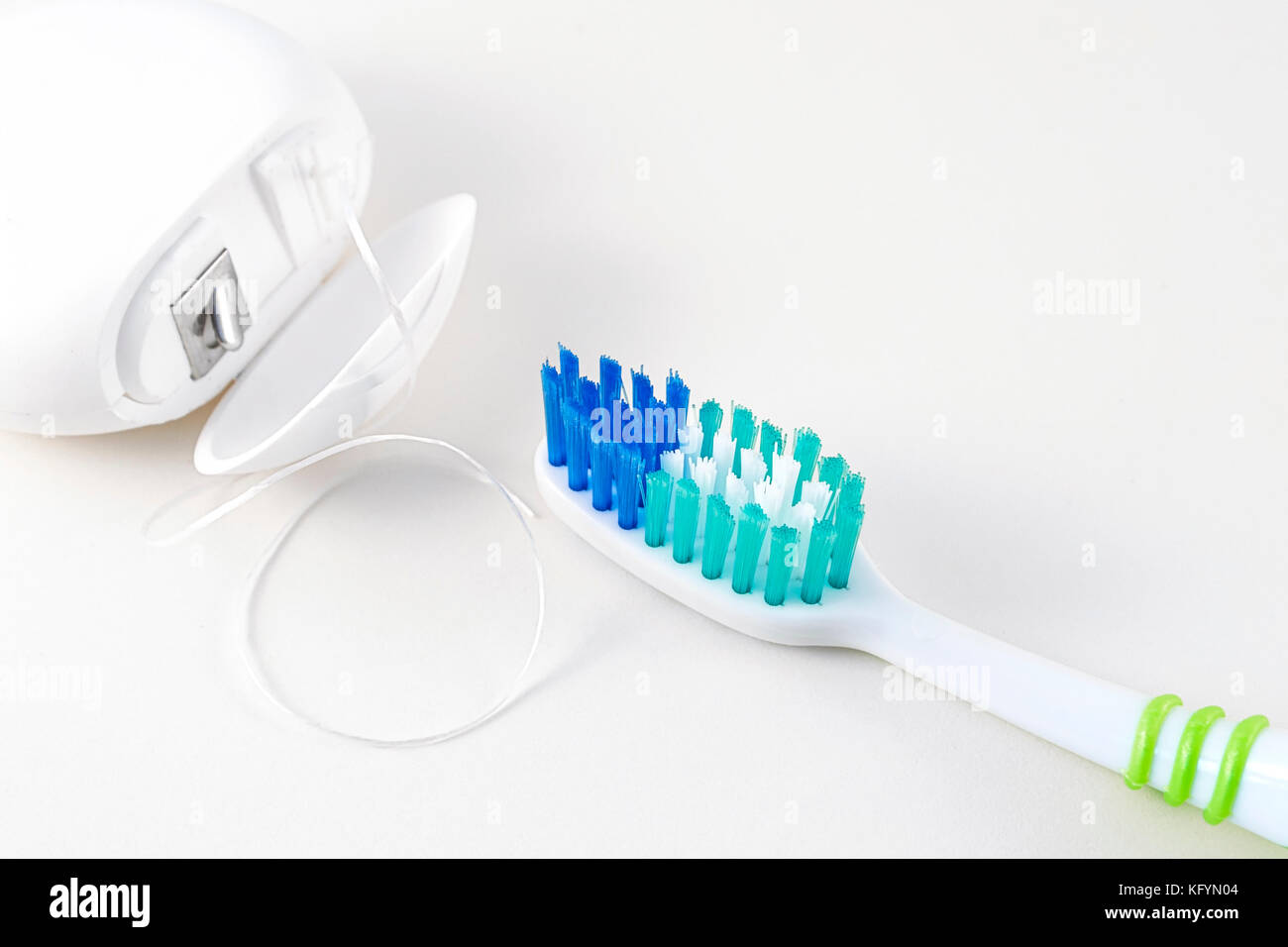 Toothbrush and dental floss on white background Stock Photo - Alamy