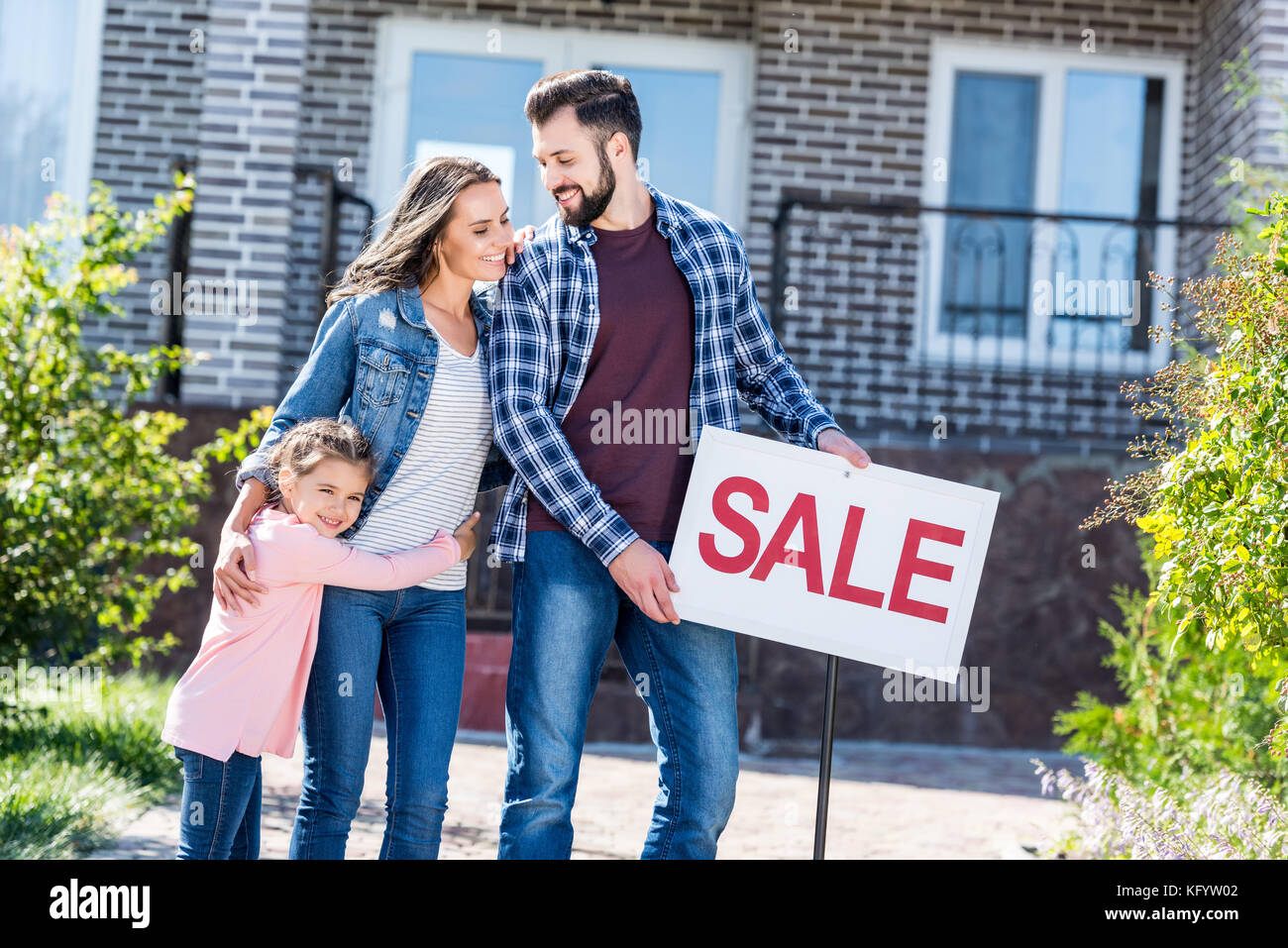 family standing in front of house on sale Stock Photo - Alamy