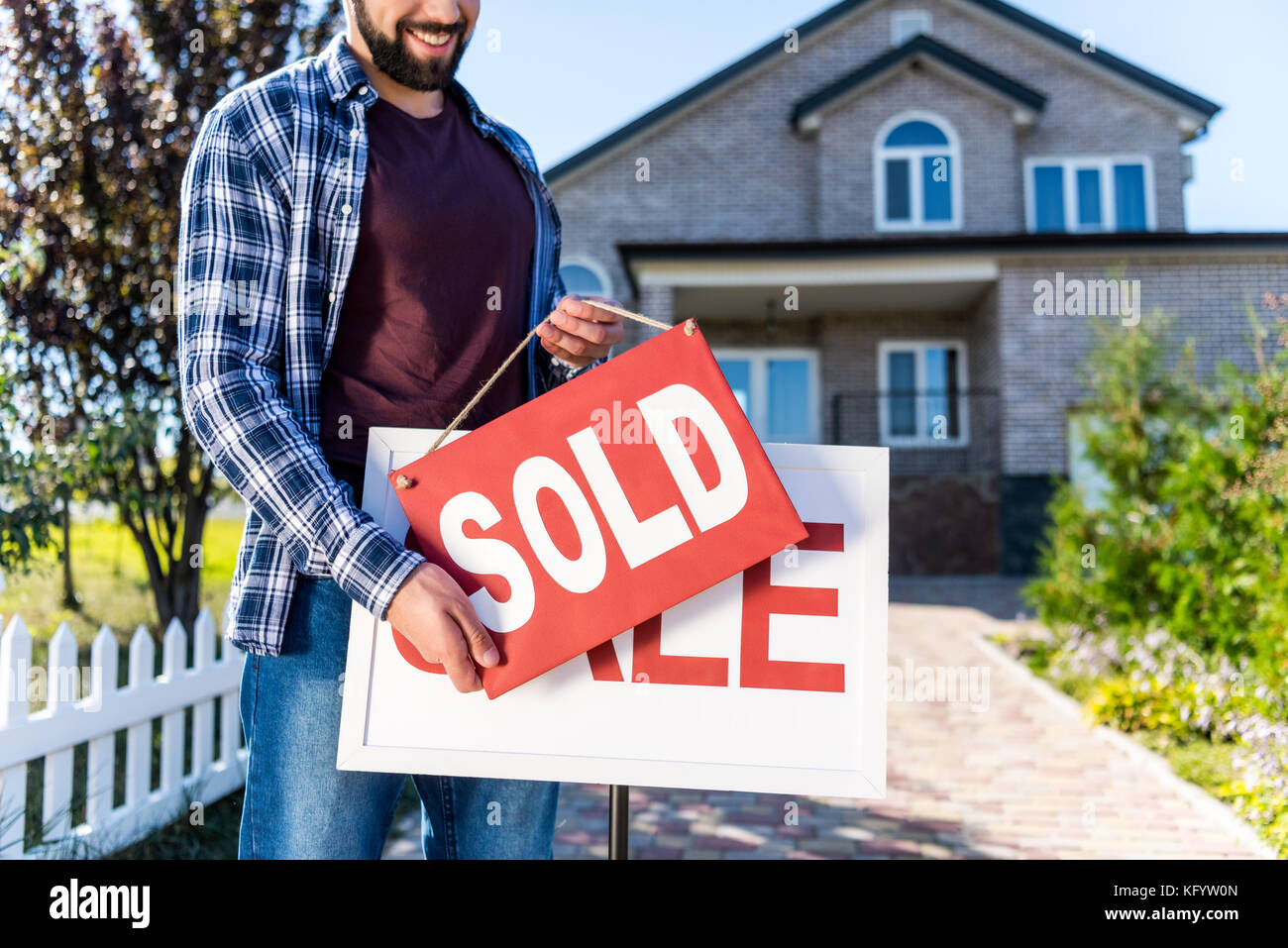 man hanging sold sign Stock Photo - Alamy