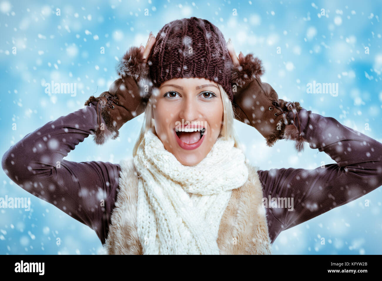 Young cheerful girl in winter clothes with hands on her head, rejoicing ...