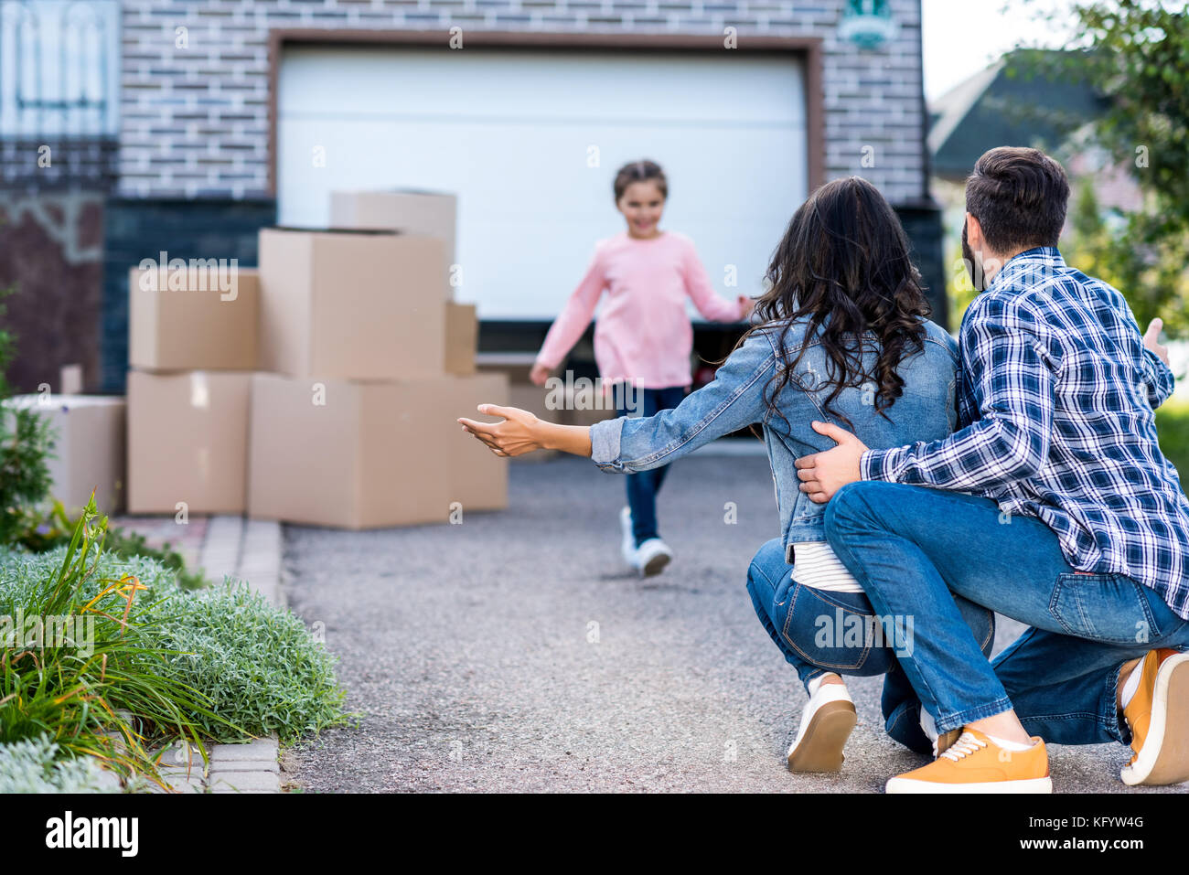 girl running to hug parents Stock Photo - Alamy