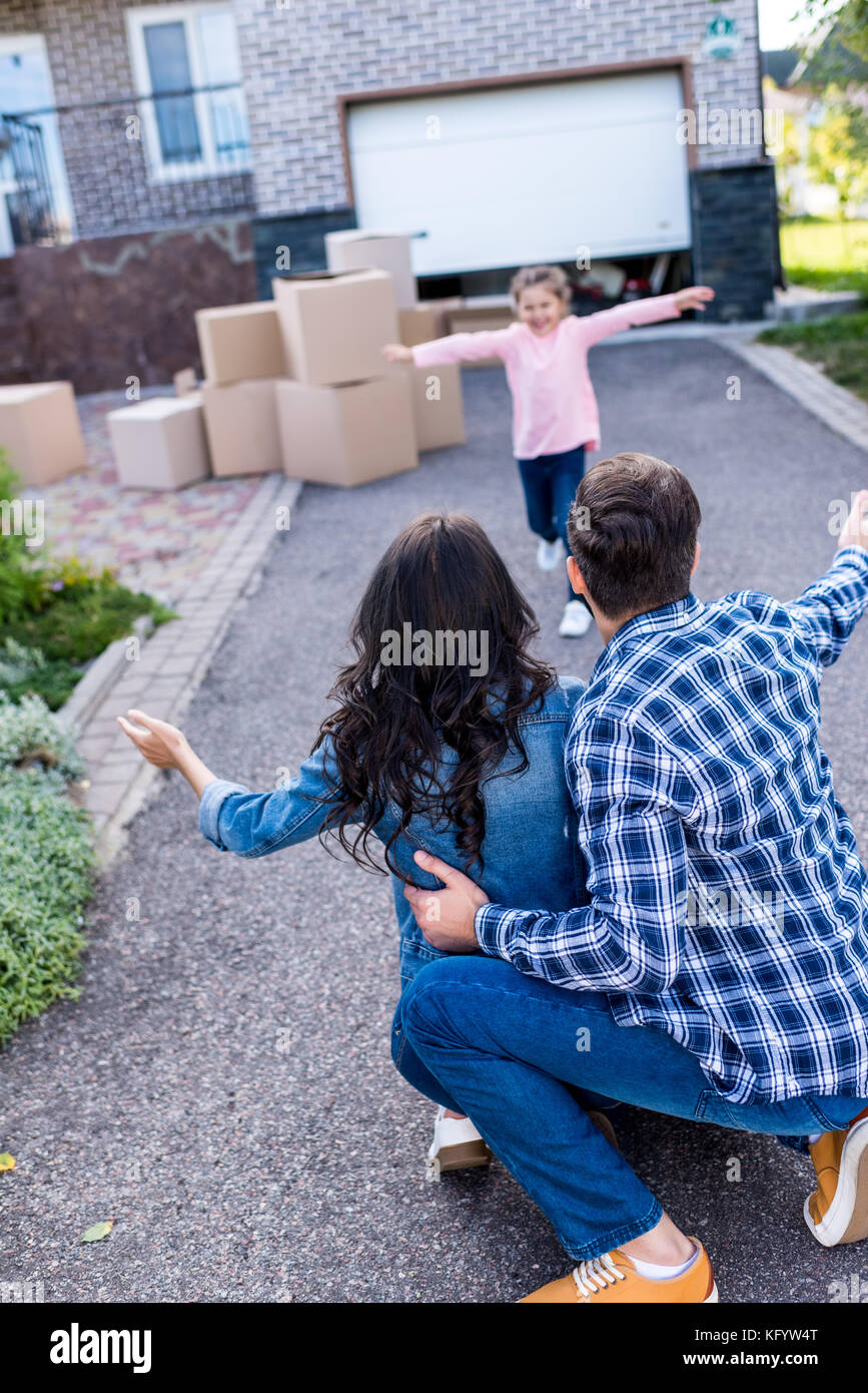 girl running to hug parents Stock Photo - Alamy