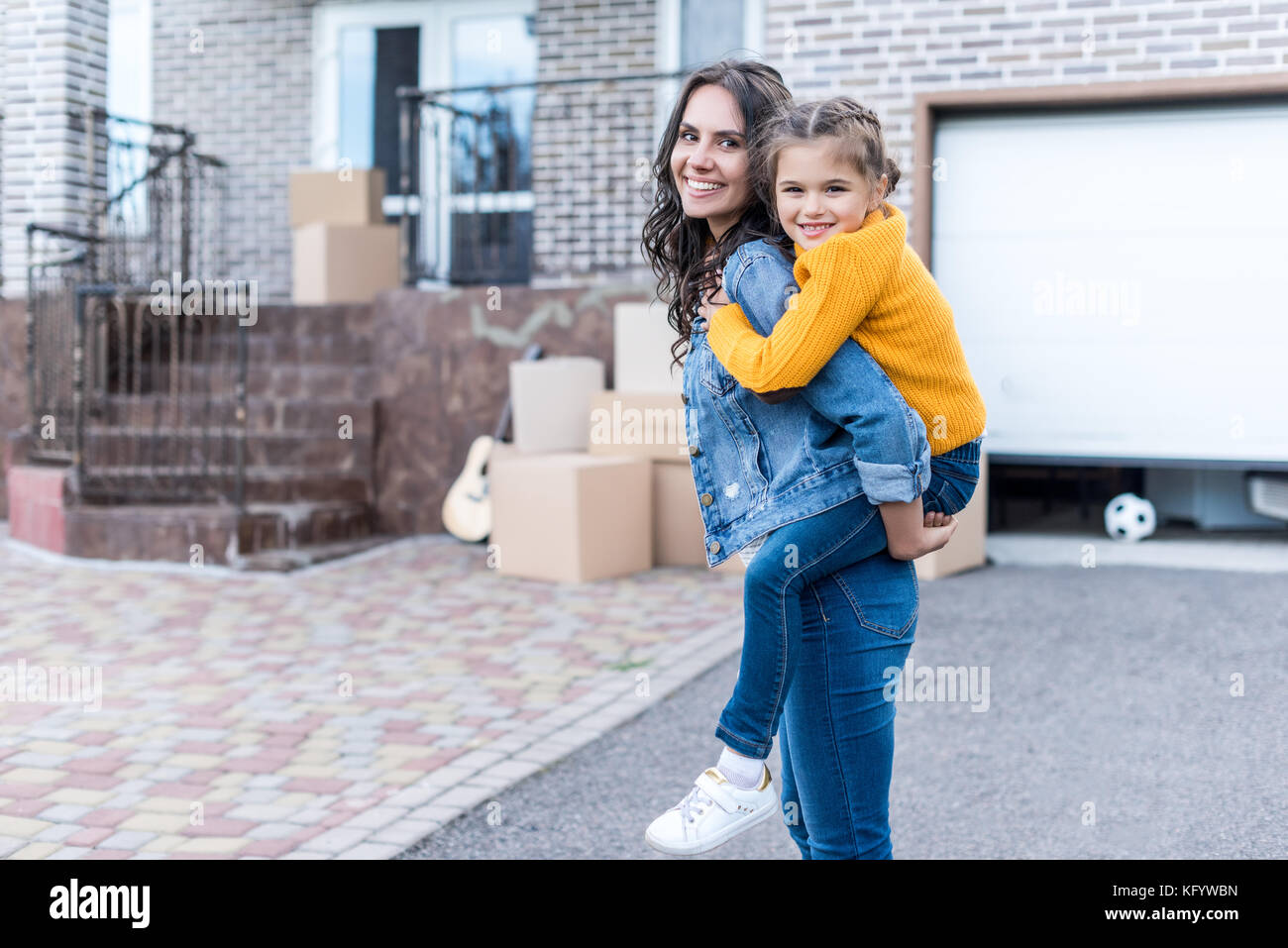 daughter piggyback riding mother Stock Photo - Alamy