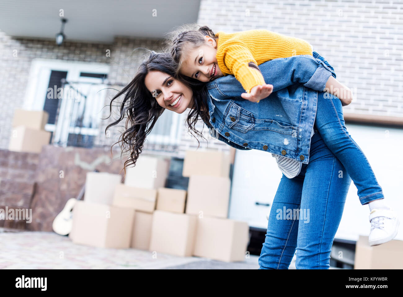 daughter piggyback riding mother Stock Photo - Alamy