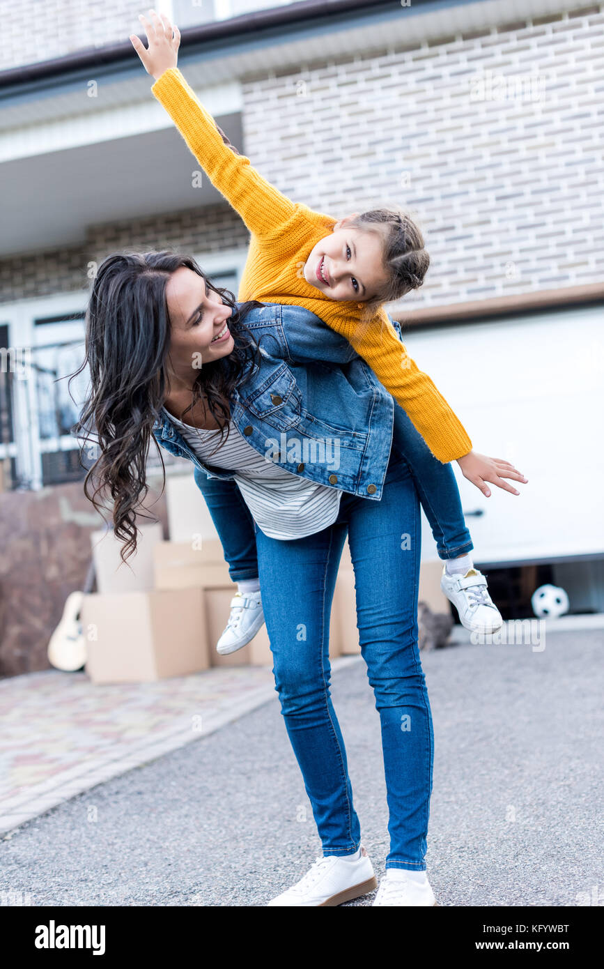 daughter piggyback riding mother Stock Photo - Alamy