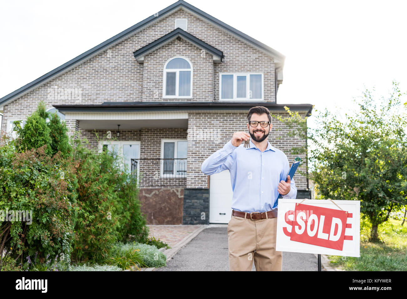 realtor with keys of sold house Stock Photo - Alamy
