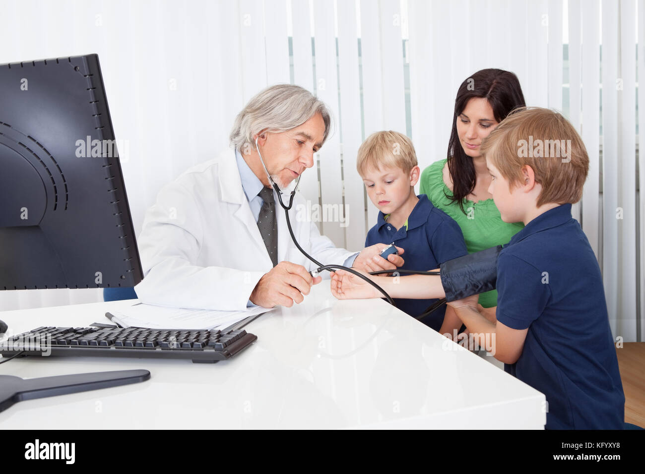 Doctor checking young kids at the office Stock Photo - Alamy