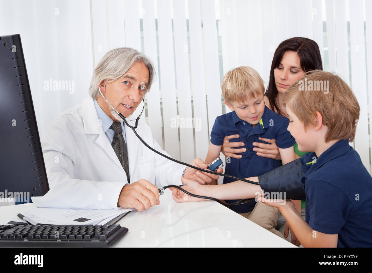 Doctor checking young kids at the office Stock Photo - Alamy