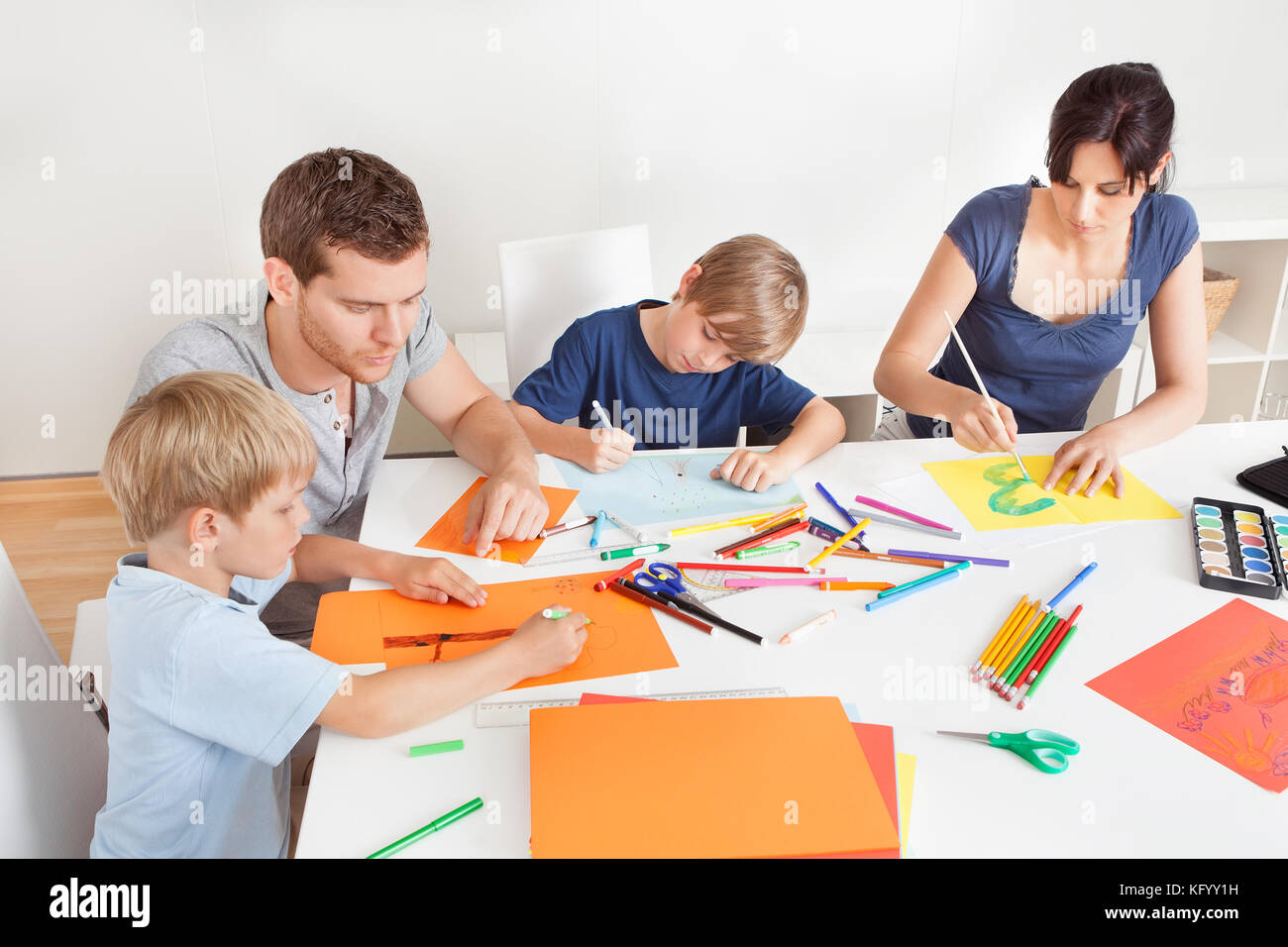 Young family drawing together with colorful pencils at home Stock Photo ...