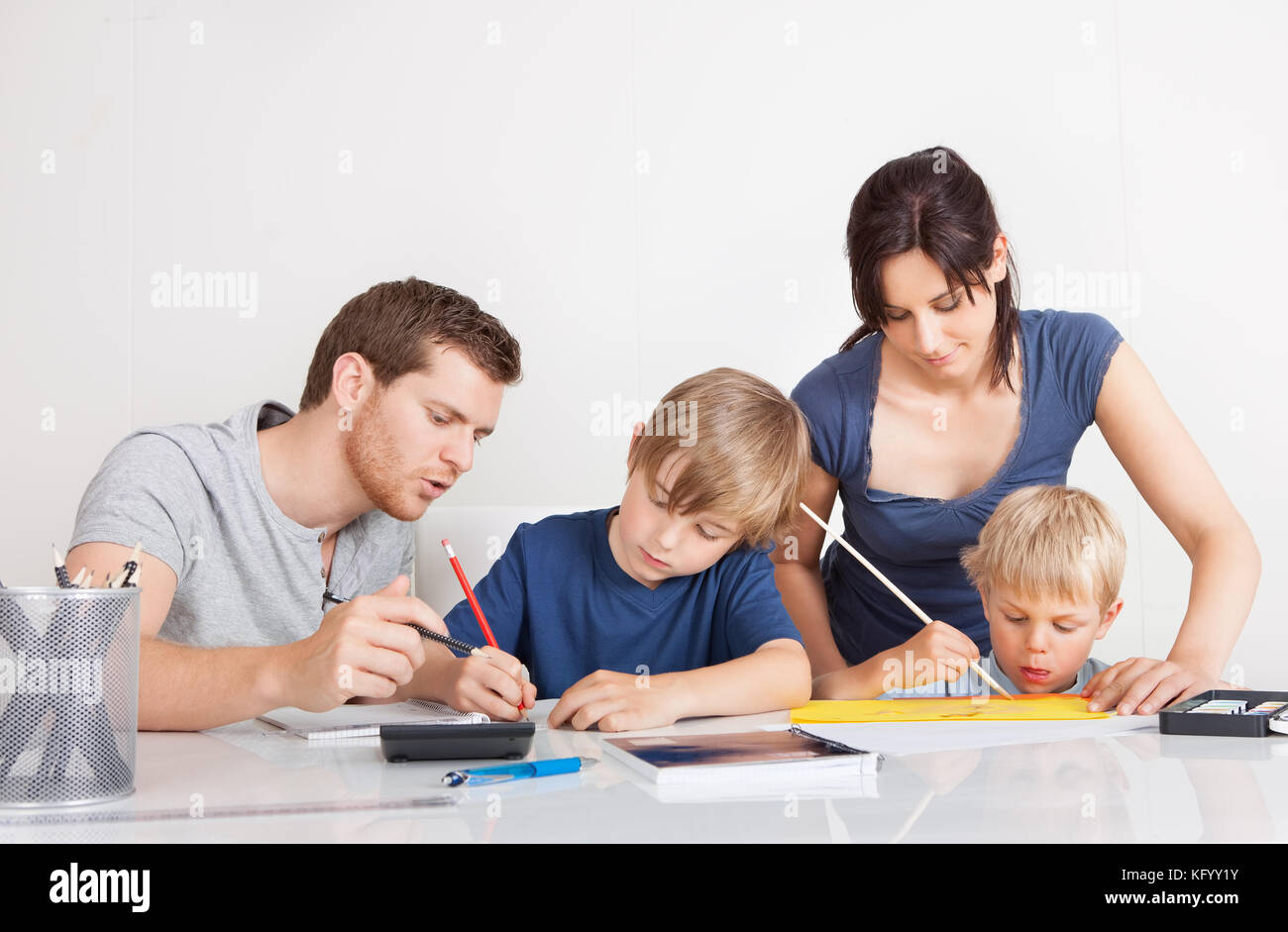 Young family doing homework together at home Stock Photo - Alamy