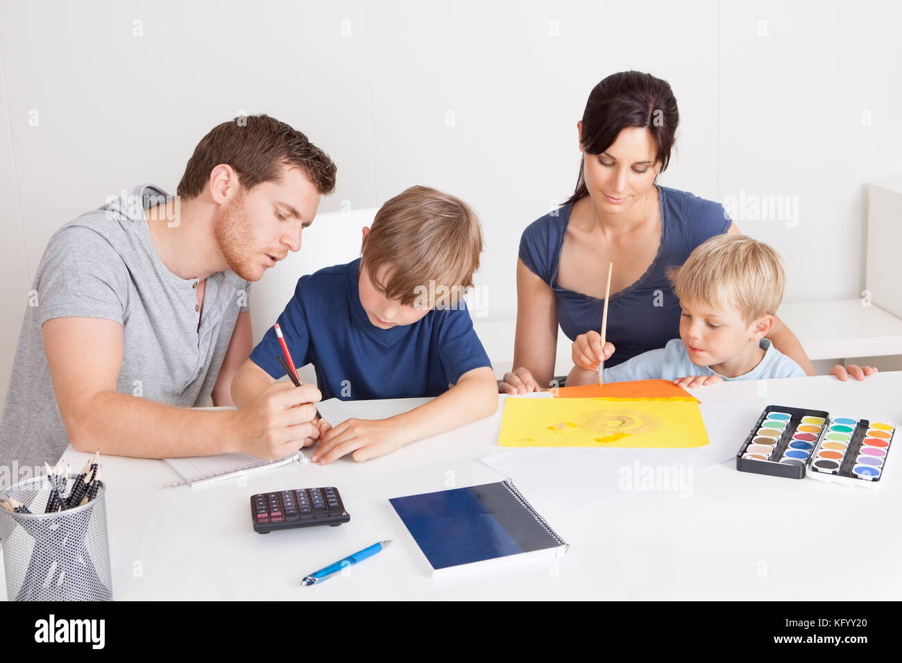 Young family drawing together with colorful pencils at home Stock Photo ...