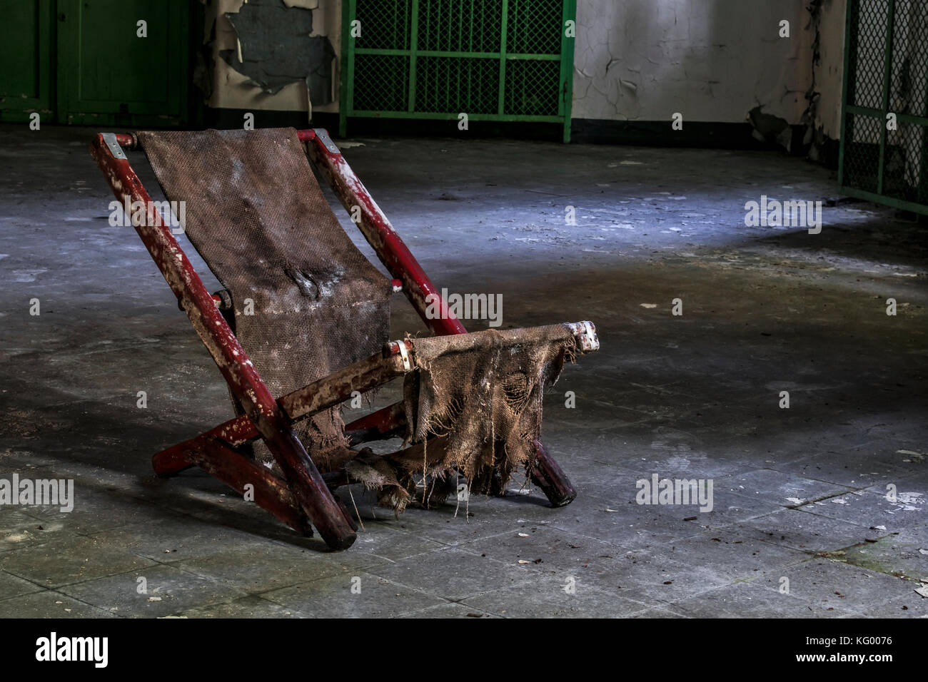 a scary shot of a chair in darkness, in a room of an abandoned ...
