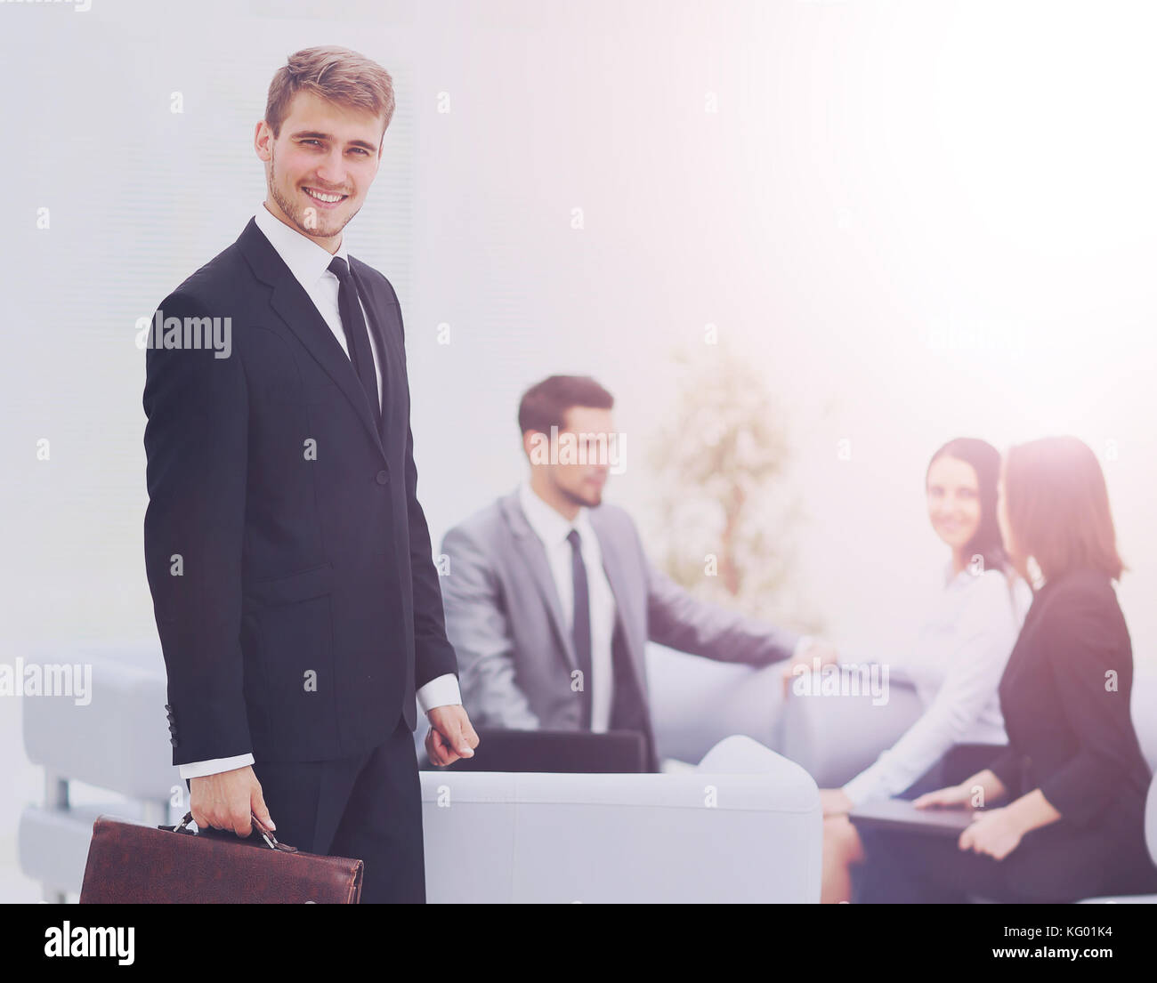 Successful business man standing with his staff in background at Stock ...
