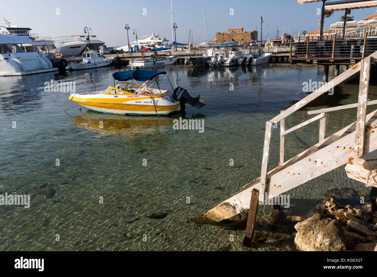 Steps down to the sea with yellow boat, Paphos harbour, Cyprus Stock ...