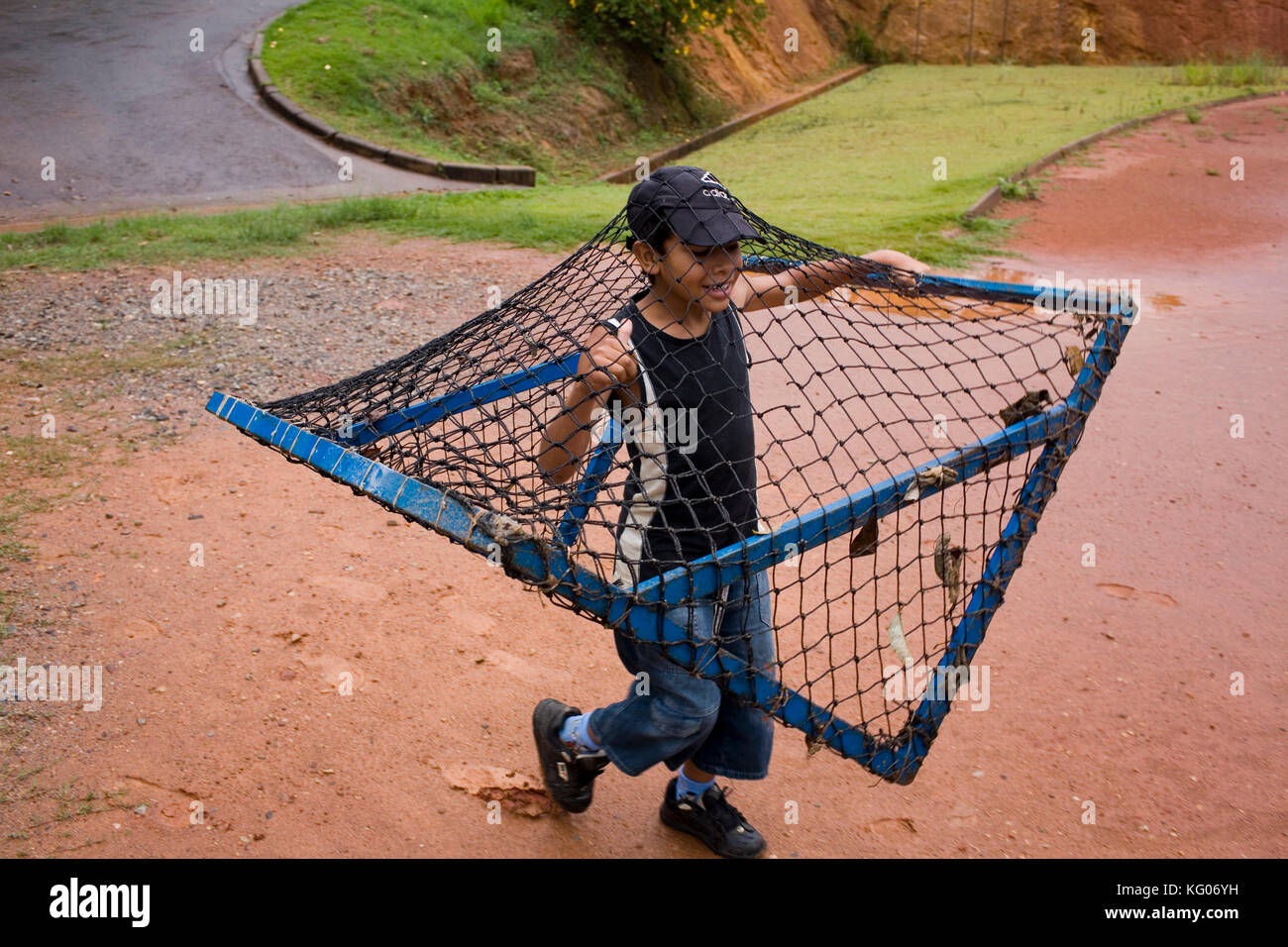 A young boy carrying goalposts for a soccer training session in Brazil ...