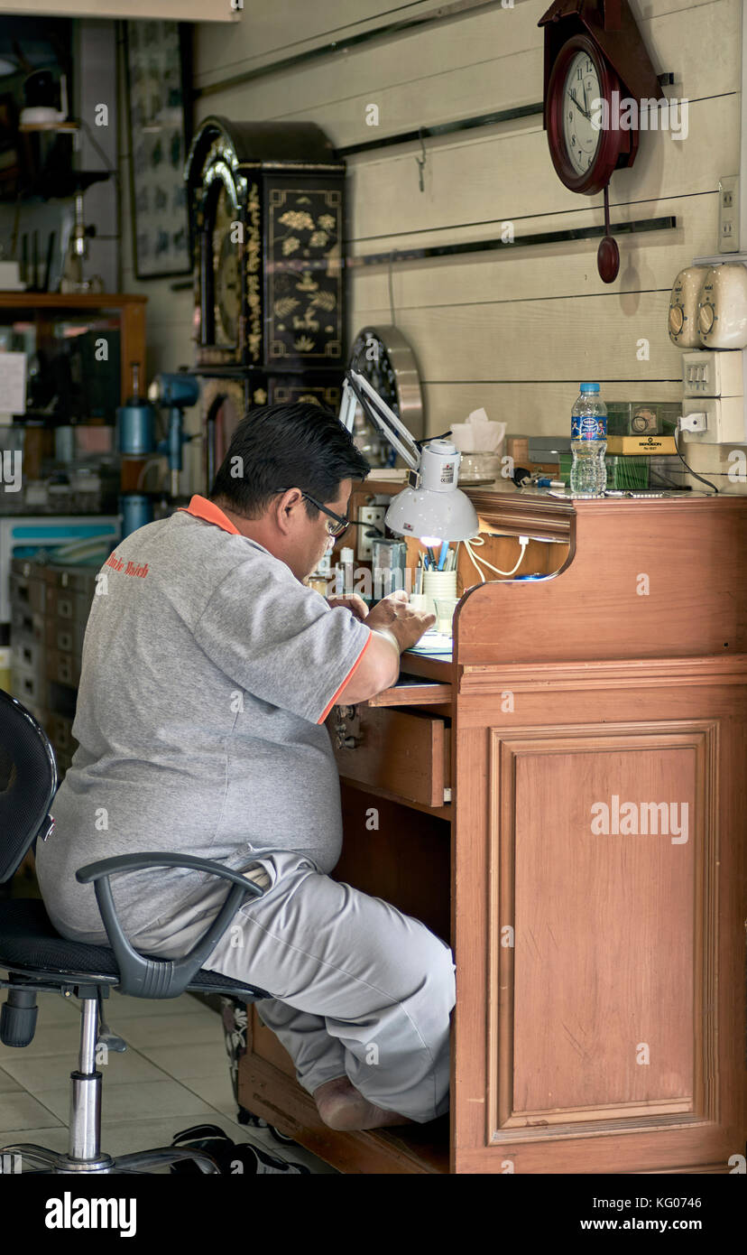 Watchmaker and repair man at work in his shop, Thailand Southeast Asia ...
