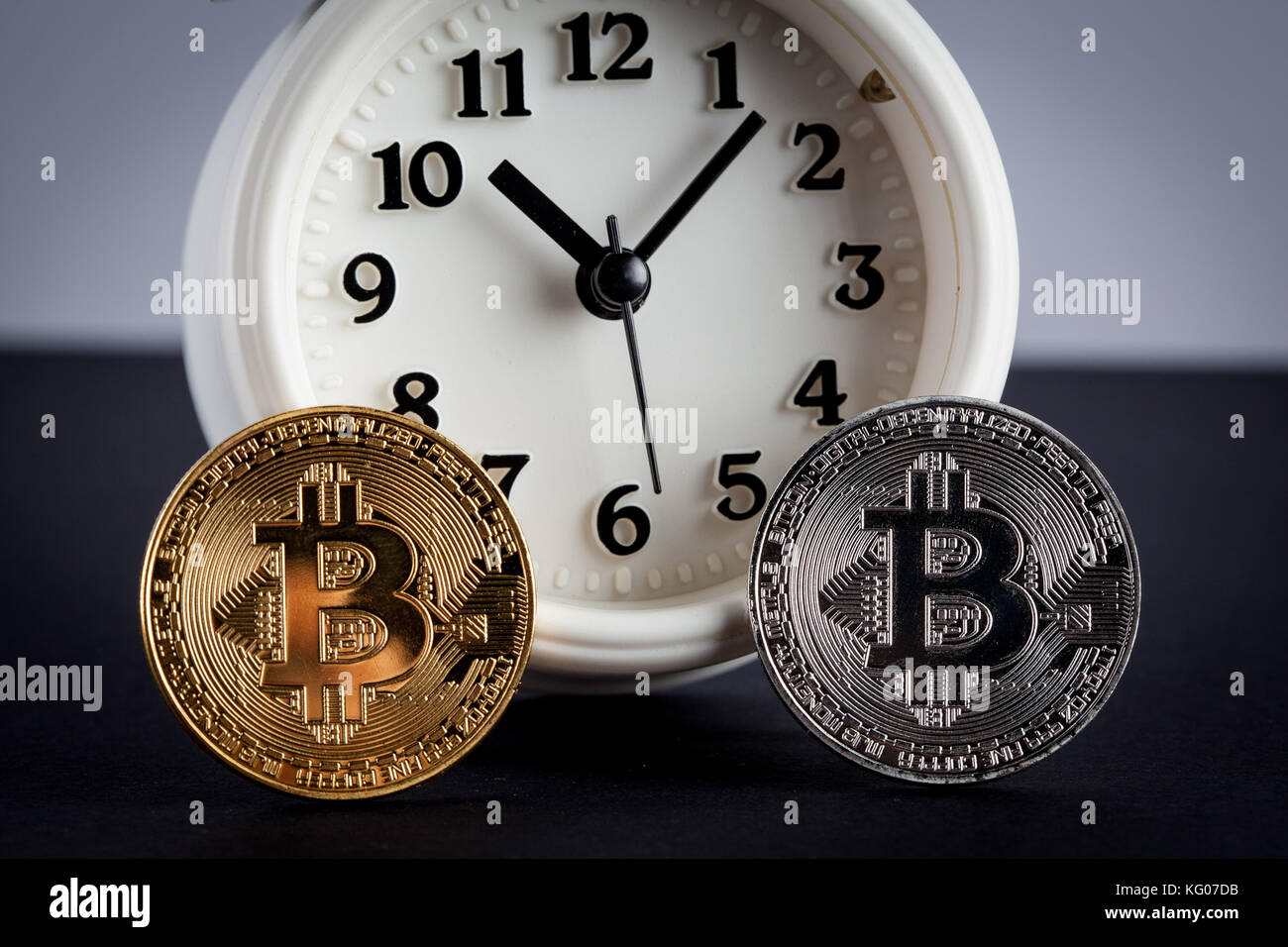 Two bitcoins and vintage alarm clock closeup Stock Photo - Alamy