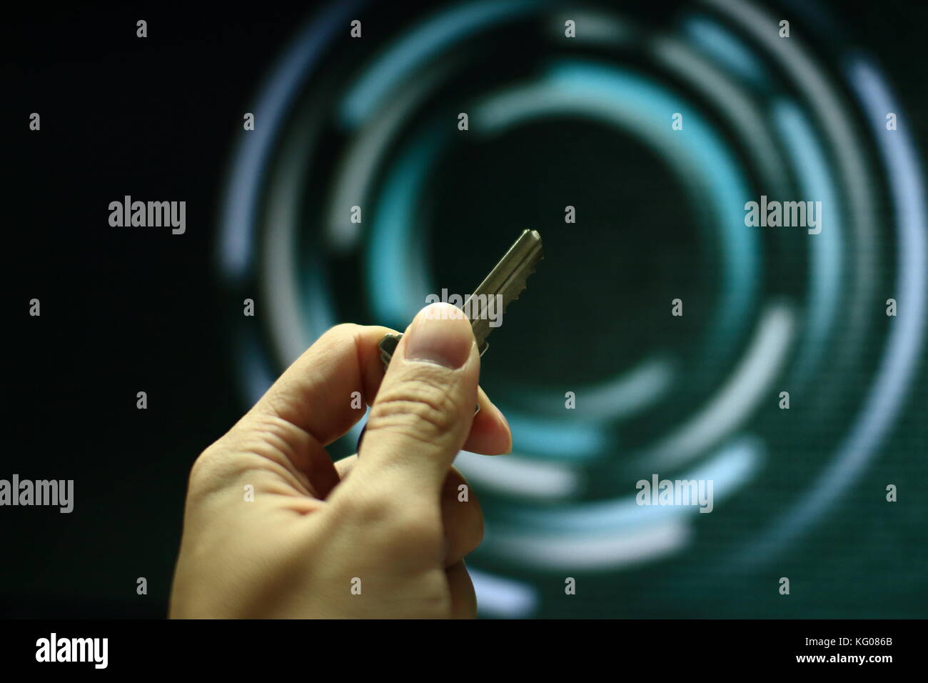 hand holding Key in front of a computer screen. Key to power and ...