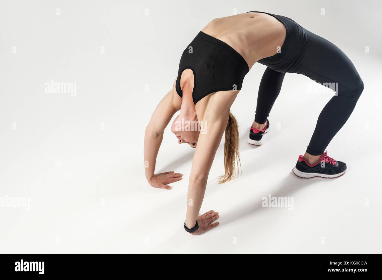 Pilates pose. Athletic woman doing hard exercising. Indoor shot, gray ...