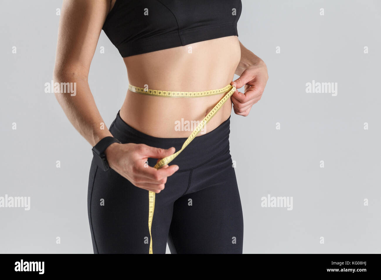 Diet concept, perfect stomach. Woman holding centimeter. Studio shot ...