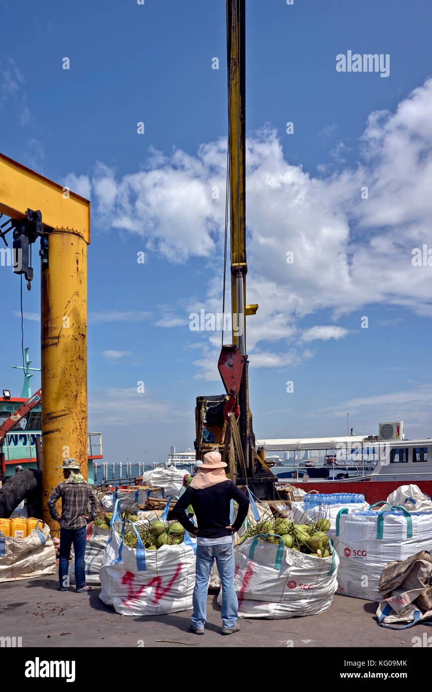 Crane loading and unloading boat. Dockworkers at Pattaya commercial ...