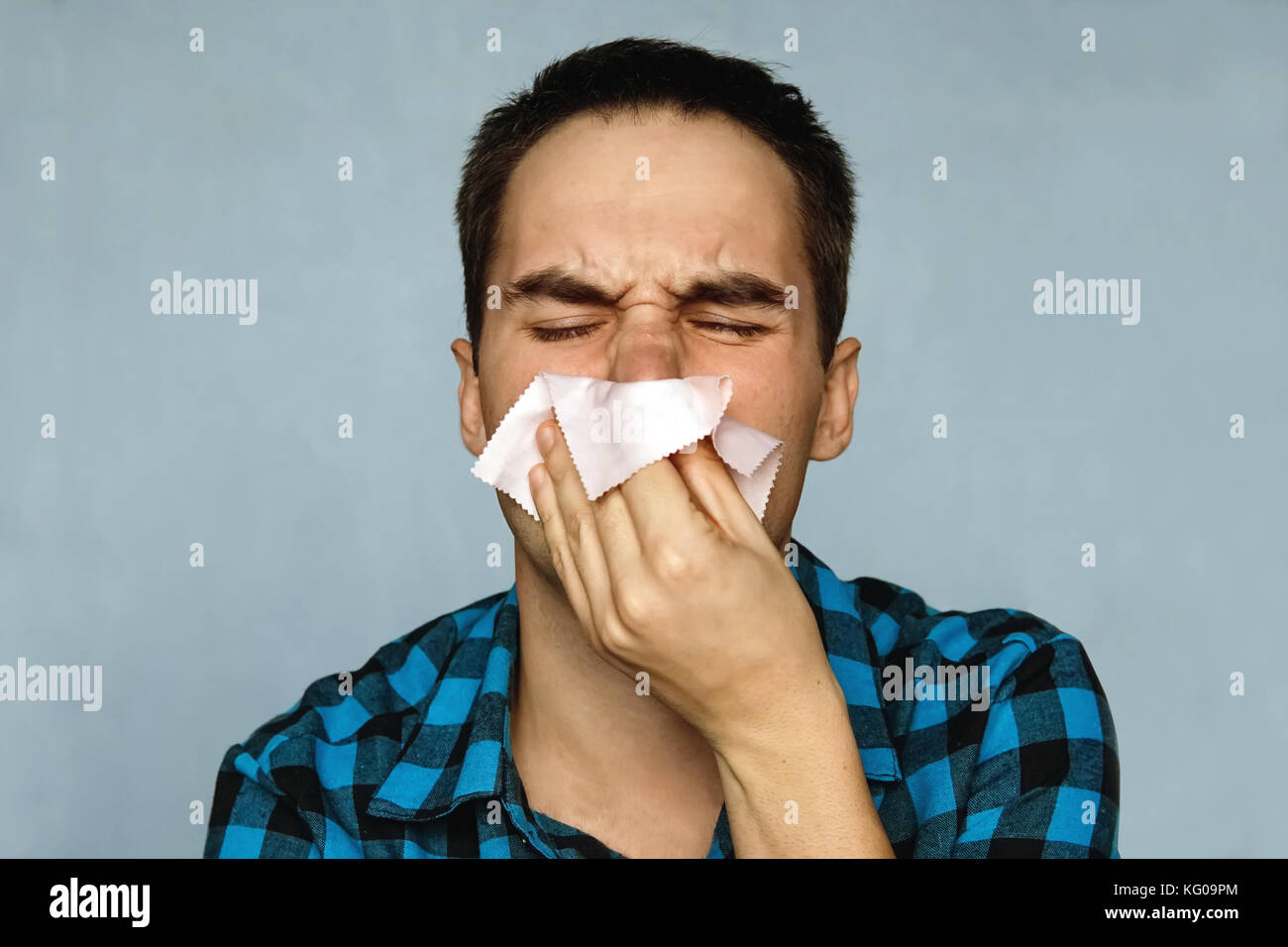 the man has a runny nose. The person with a cold sneezes into a ...