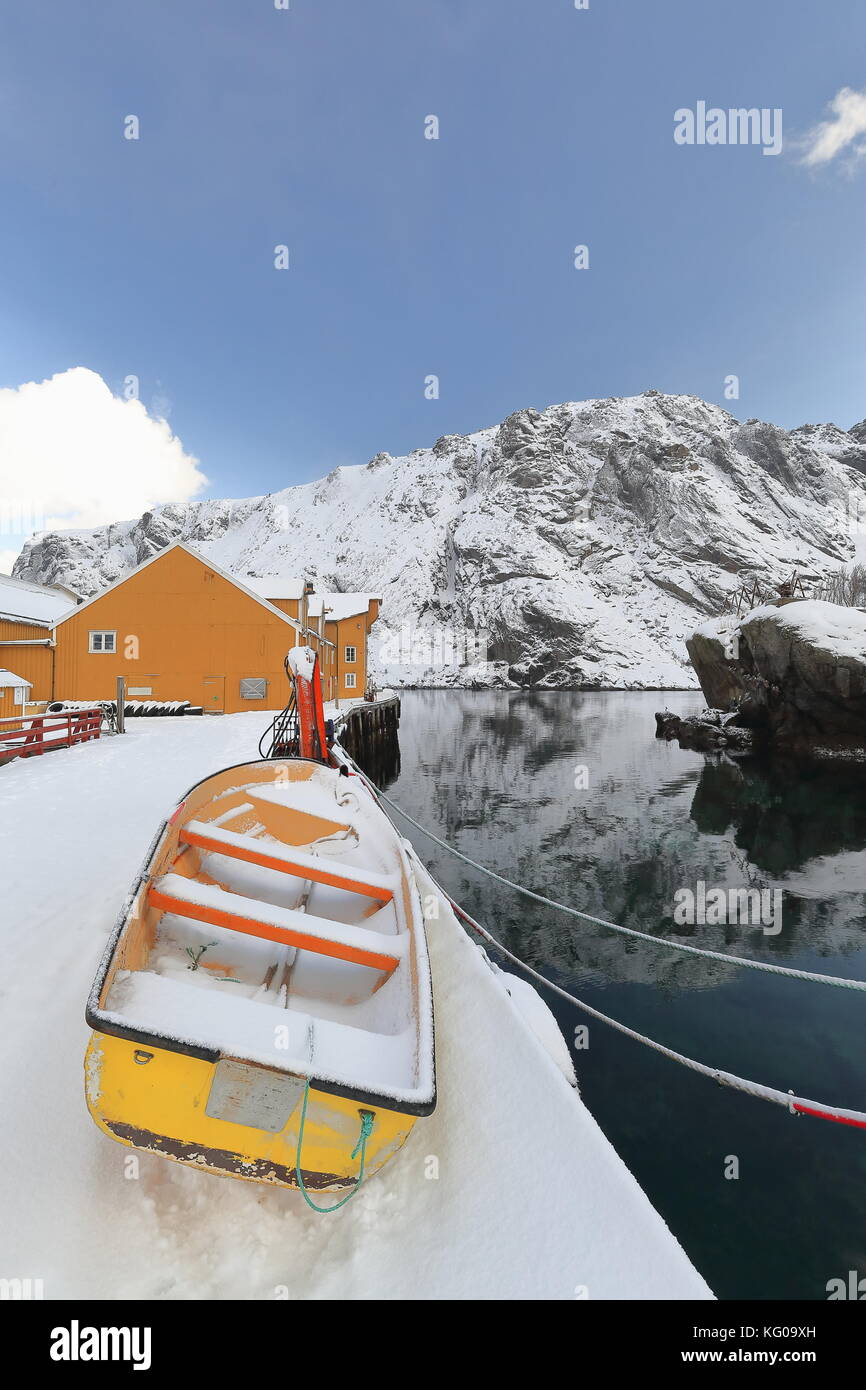 Fiberglass yellow fishing rowboat ashore on snowcovered gangplank-N ...