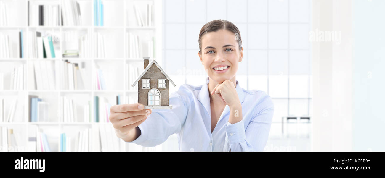 home concept smiling woman showing house model, real estate and design ...