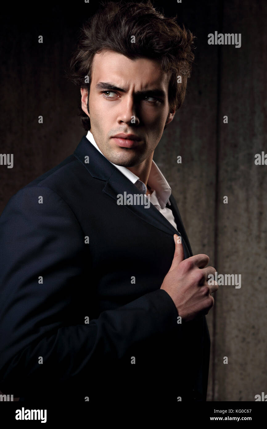 Confident handsome man with strained look posing in blue fashion suit ...