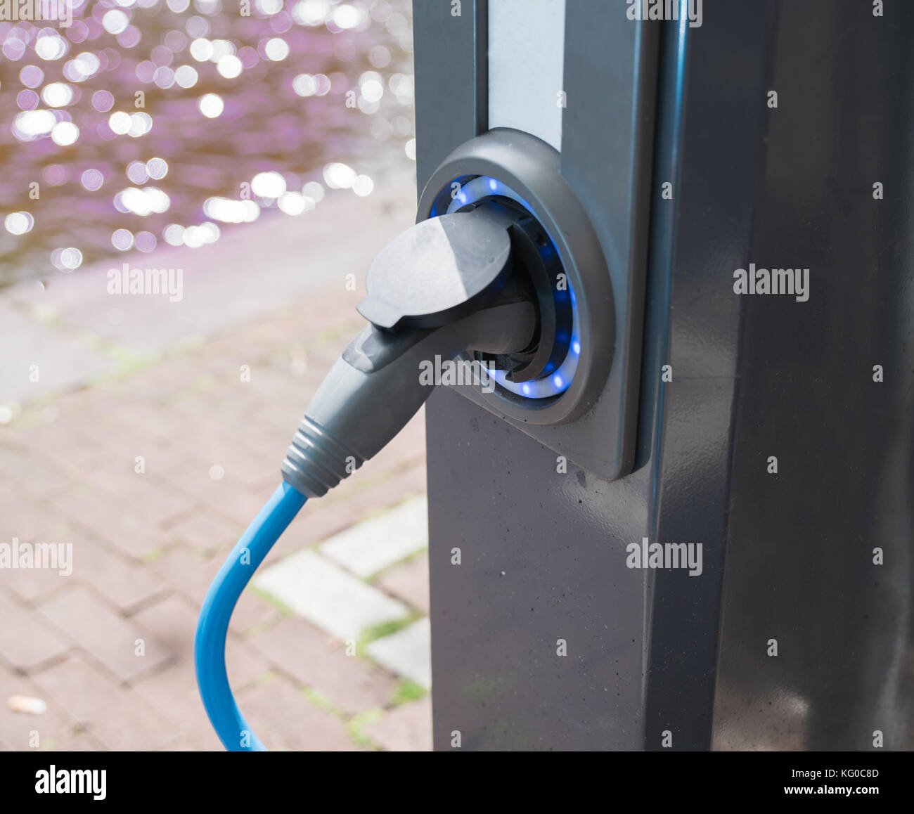 Car recharge point on side of street with cable connected Stock Photo ...