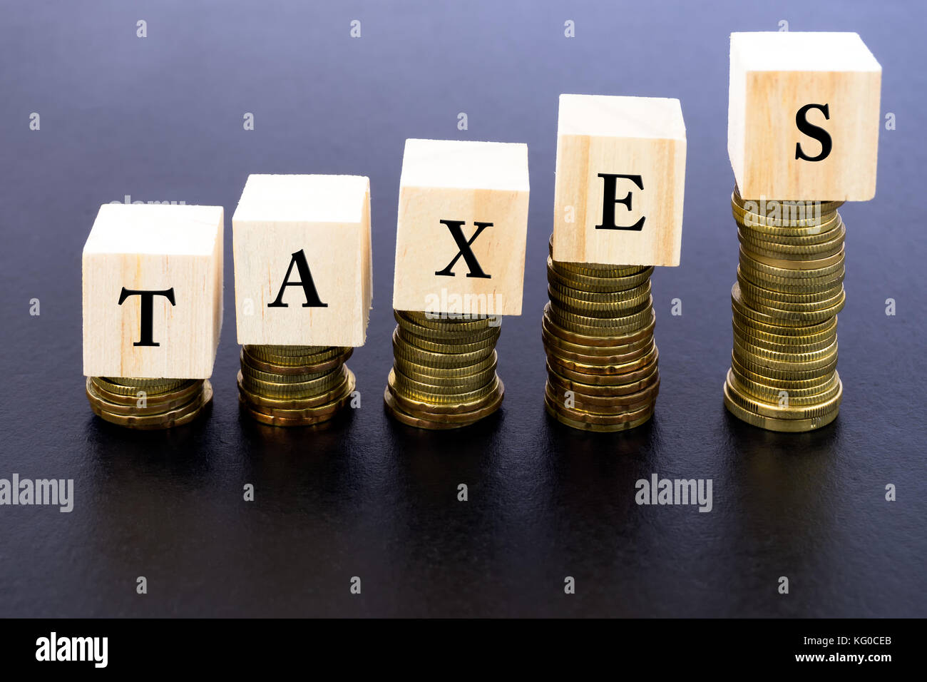 Taxes Word on Wood Block on Top of Coins Stack With Black Background ...