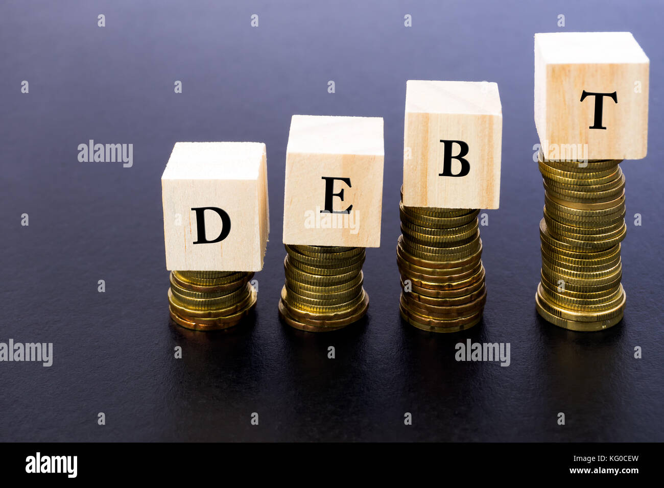 Debt Word on Wood Block on Top of Coins Stack With Black Background ...
