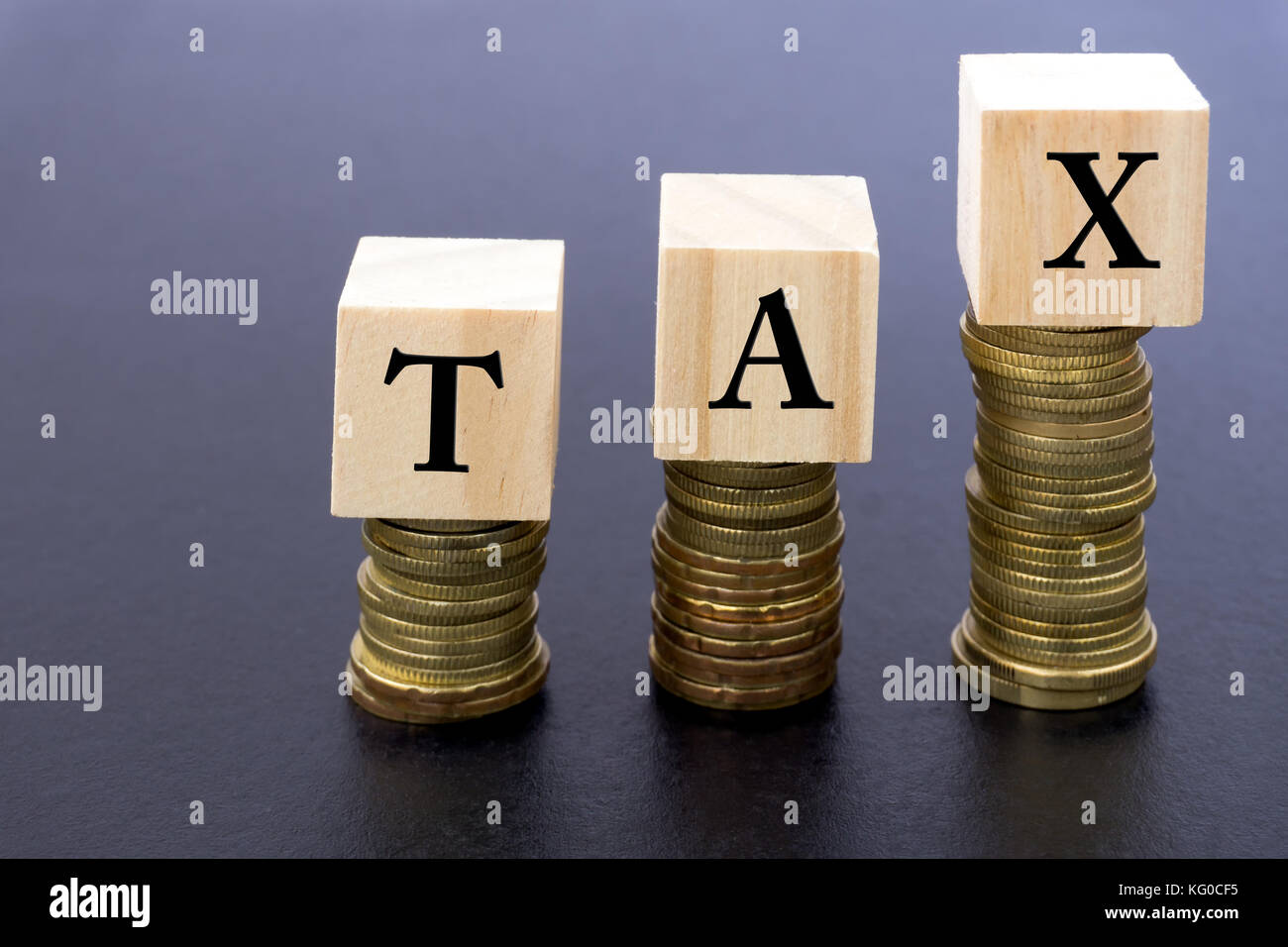 Tax Word on Wood Block on Top of Coins Stack With Black Background ...
