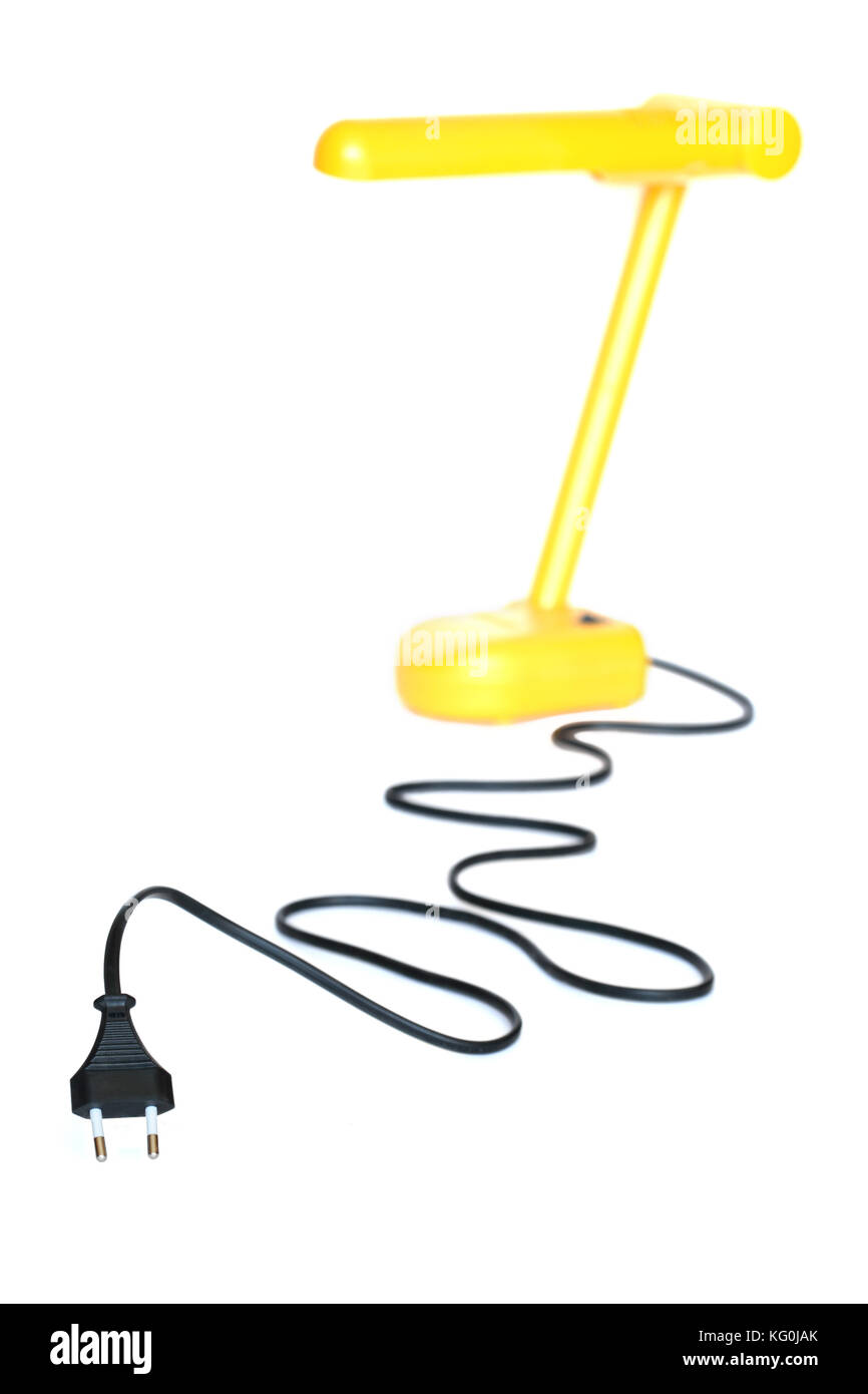 Electric plug with long black cable and yellow desk lamp on white ...