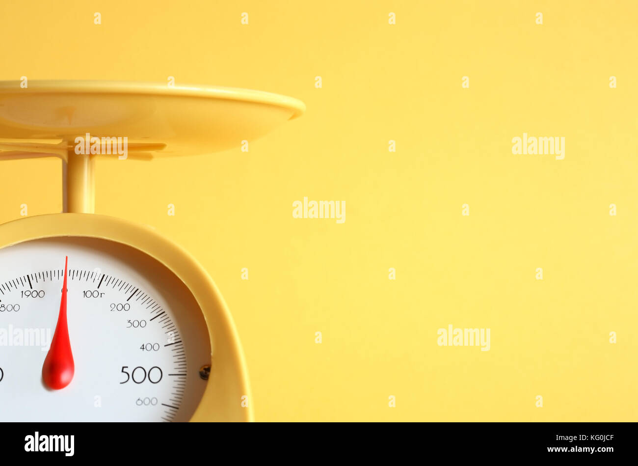 Closeup of modern kitchen scale on yellow background with copy space ...