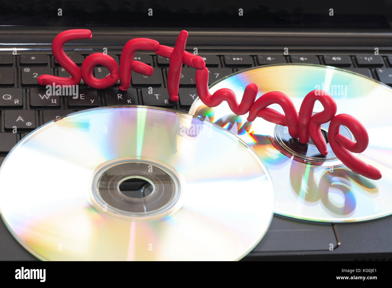 Word SOFTWARE made from red plasticine standing on CD on black computer ...